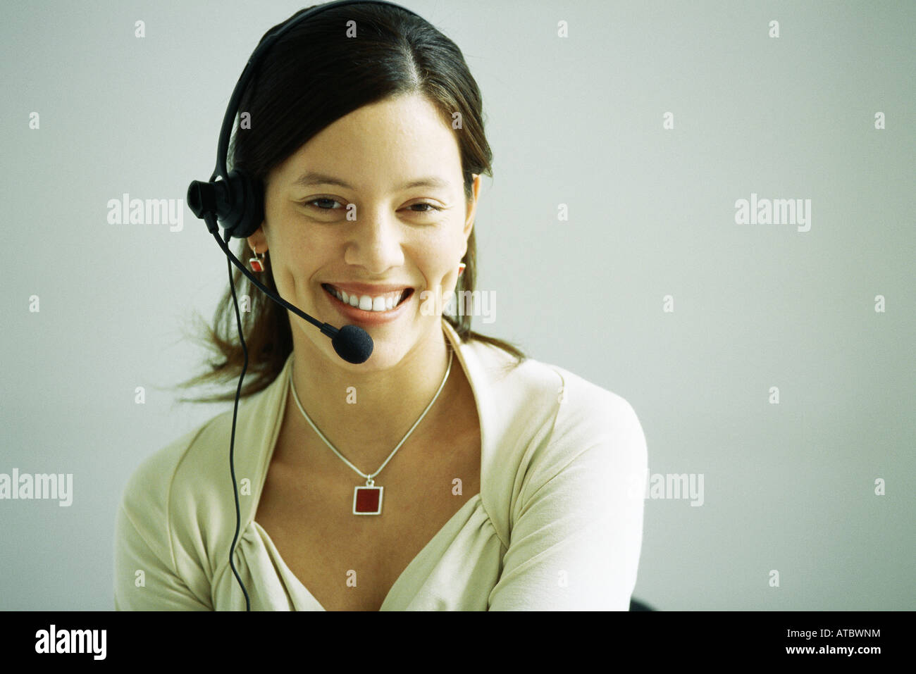 Woman wearing headset, smiling at camera, portrait Stock Photo - Alamy