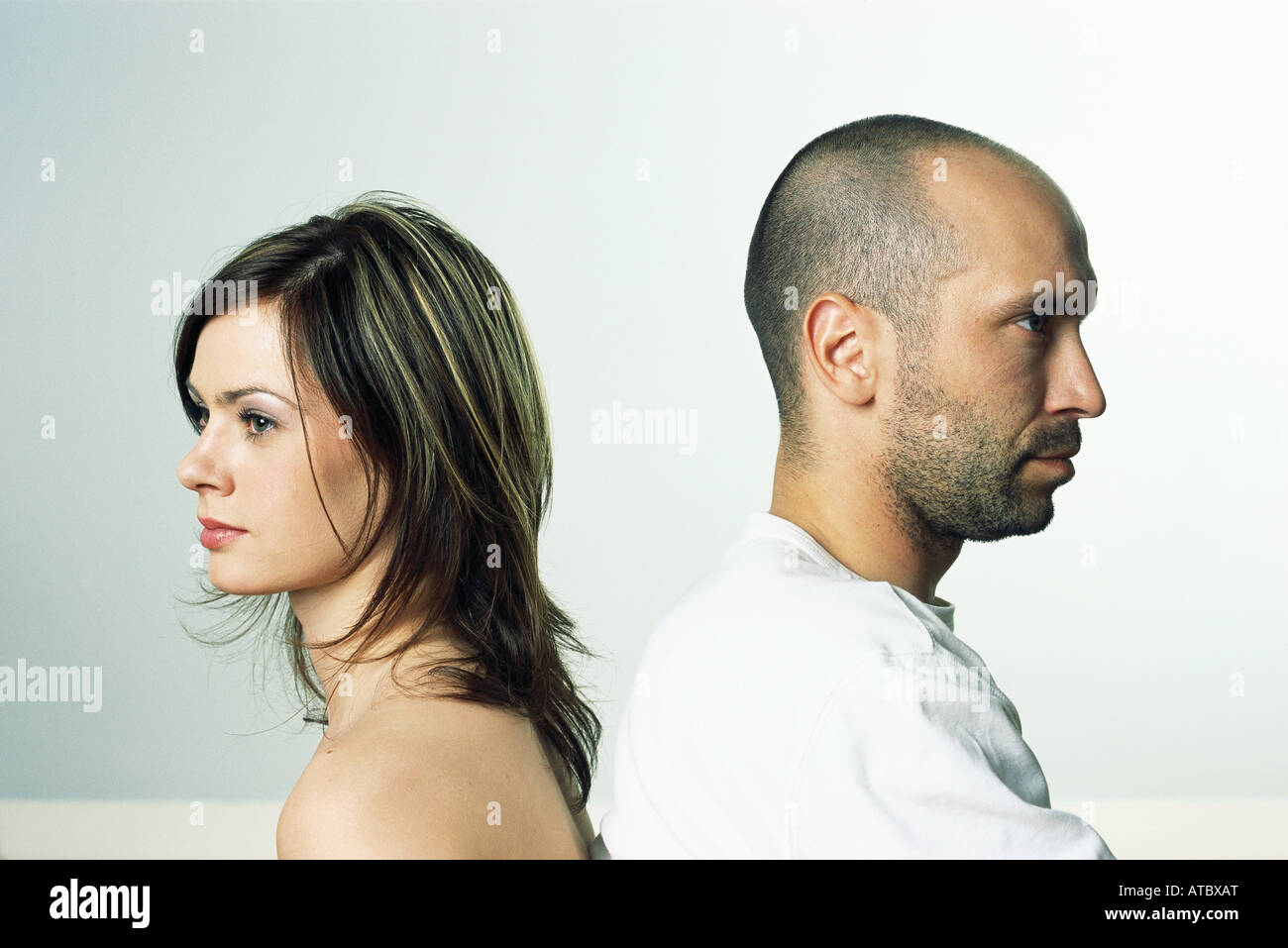 Couple back to back, both looking away, side view Stock Photo - Alamy