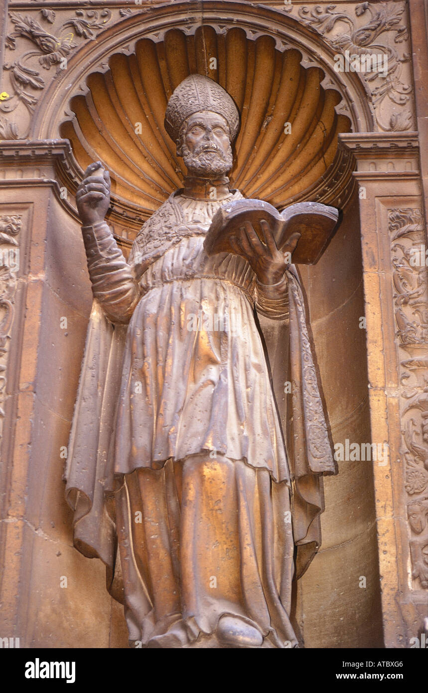 A statue of a robed religious figure with open bible held in one hand ...