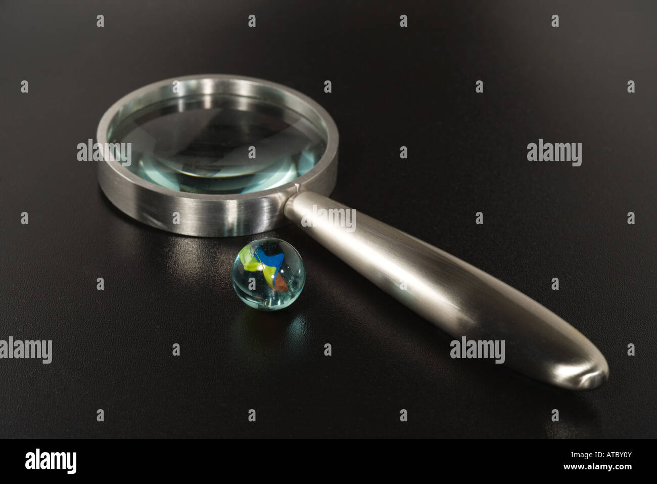 Glass marble and magnifying glass, close-up Stock Photo - Alamy