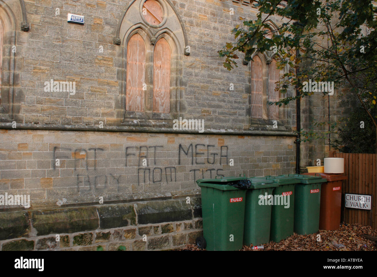 Boarded up church window, dustbins and graffiti Stock Photo - Alamy