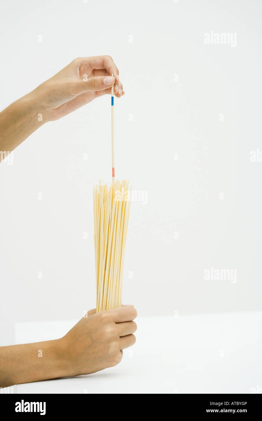 Hands holding dried pasta, measuring with stick Stock Photo - Alamy