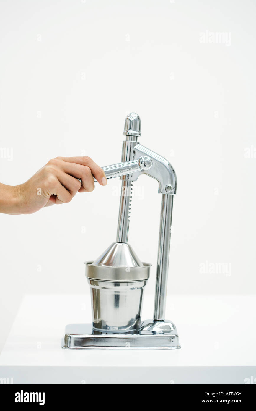 Hand using chrome juicer, cropped view Stock Photo - Alamy