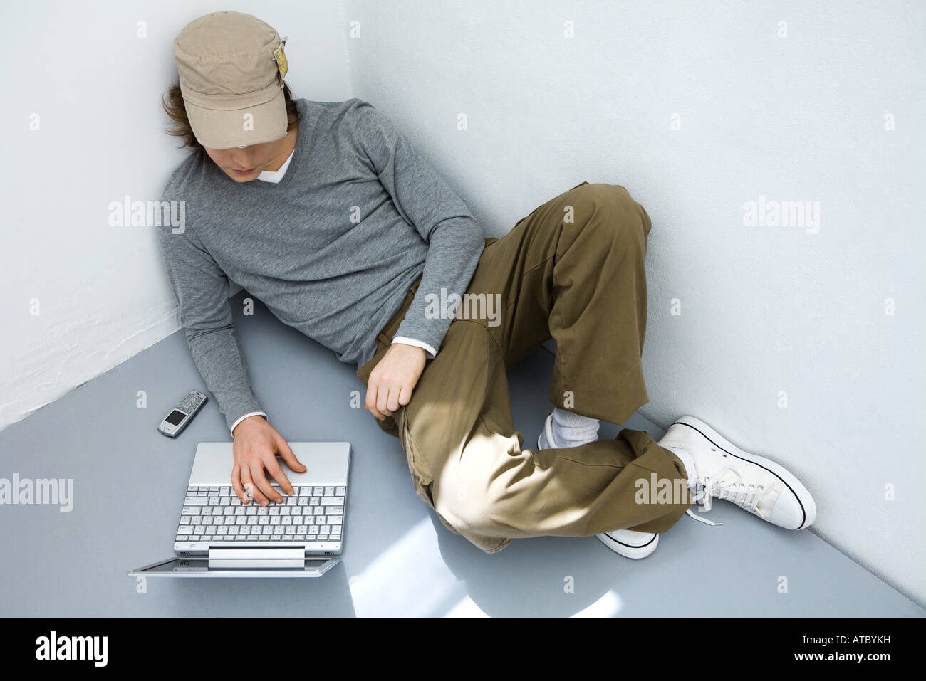Young man sitting on the ground, using laptop computer, high angle view ...