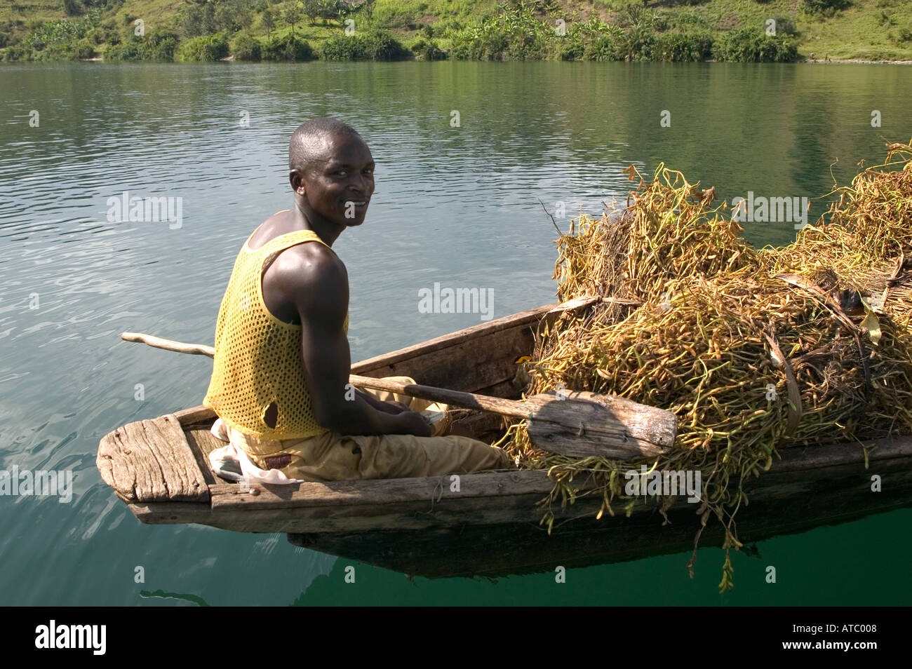 A traditional boatman carries soya on his wooden boat in Lake Kivu in ...