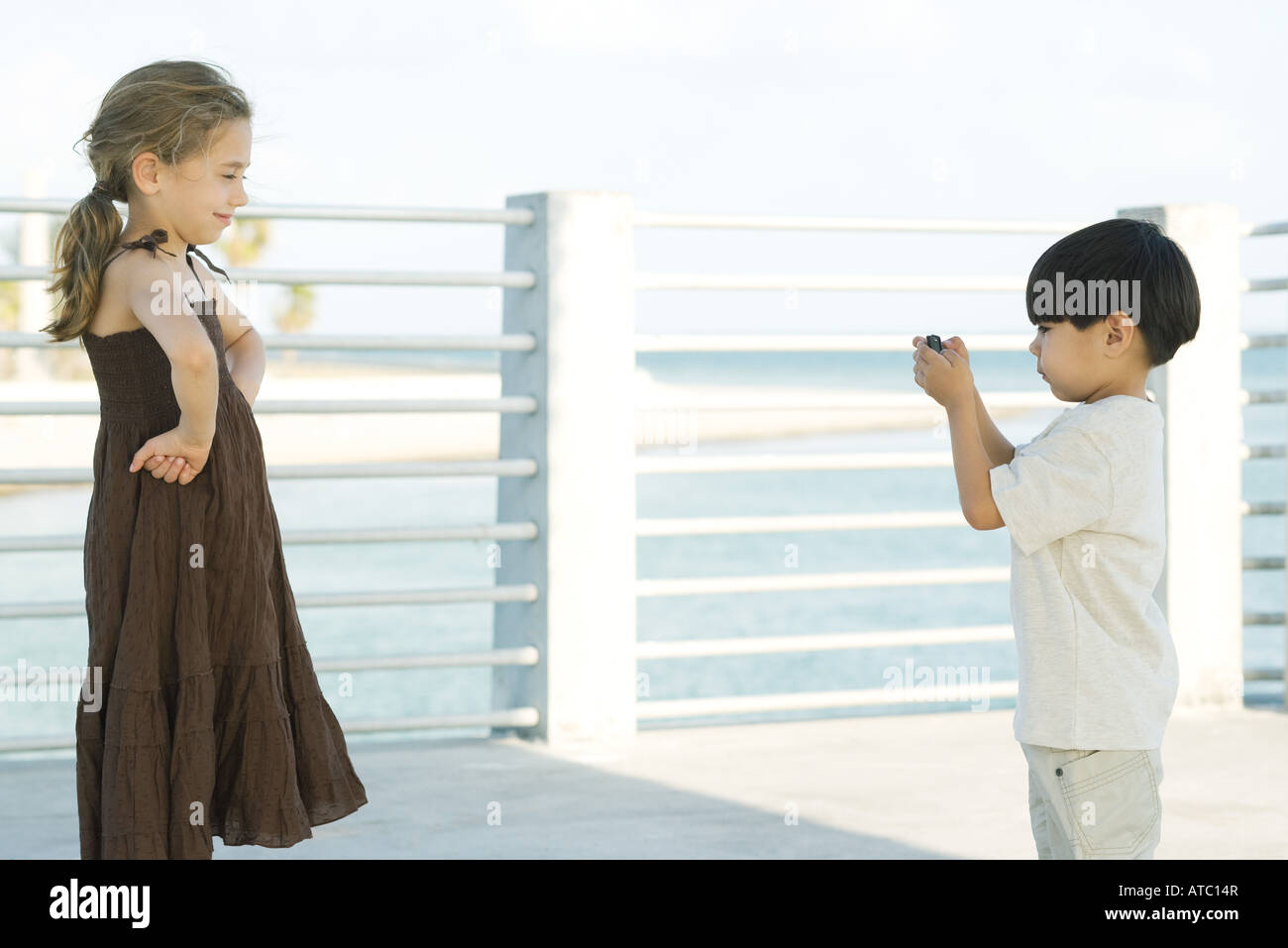 Young boy photographing friend with camera, side view Stock Photo - Alamy