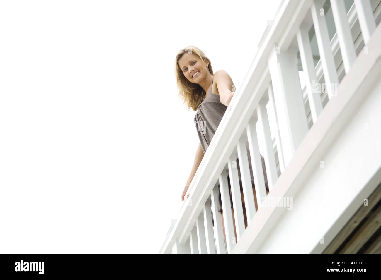 Woman looking down from balcony hi-res stock photography and images - Alamy