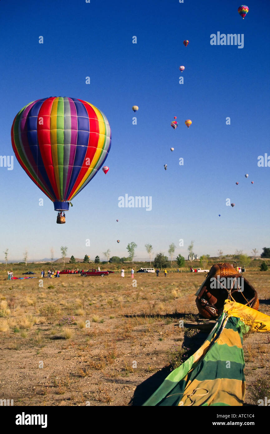 Hot air balloon and basket on ground after flight with many balloons ...