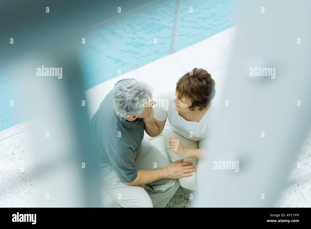 Couple sitting next to pool, high angle view, selective focus Stock ...