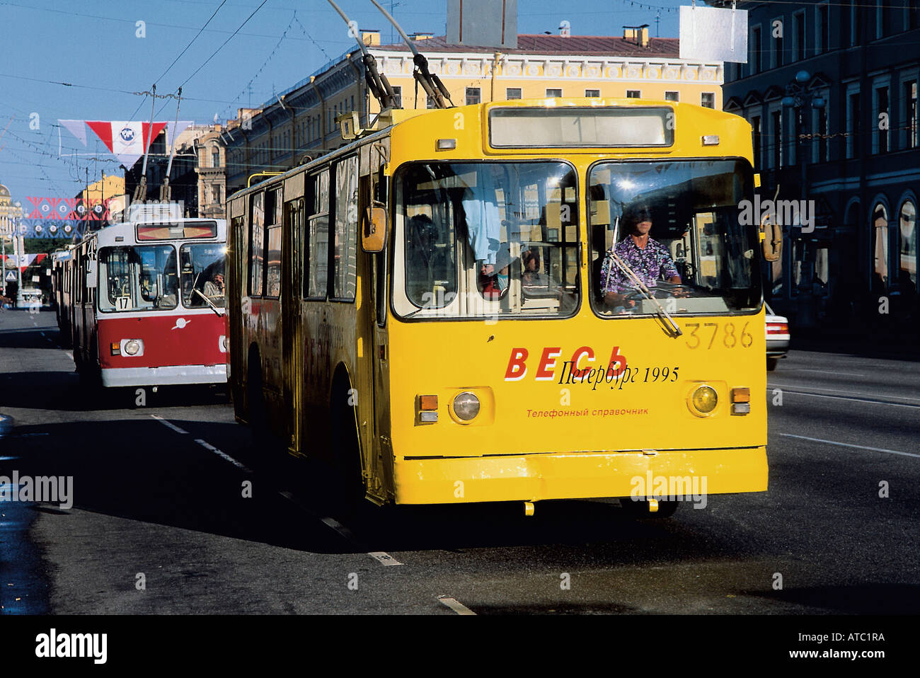 Brightly coloured trolley buses passing along the broad length of St ...