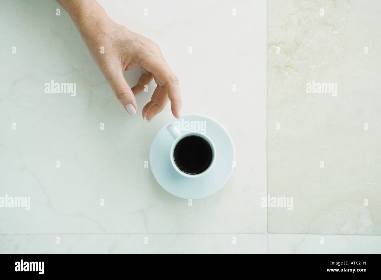 Hand reaching for coffee cup, viewed from directly above Stock Photo ...