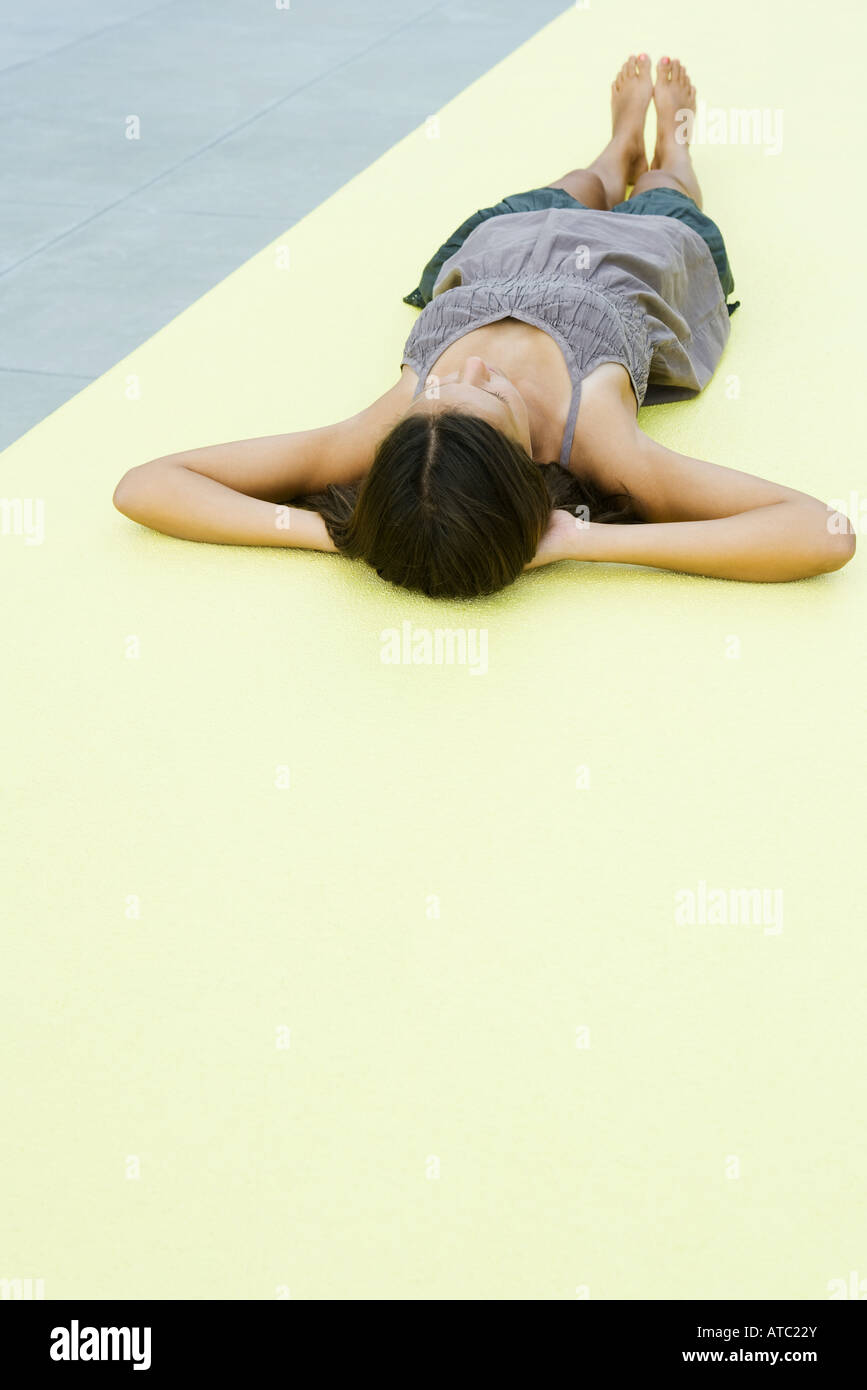 Teenage girl lying on the ground with hands behind head Stock Photo - Alamy
