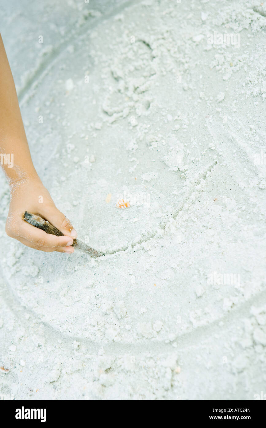 Child drawing in the sand with stick, cropped view of hand Stock Photo ...