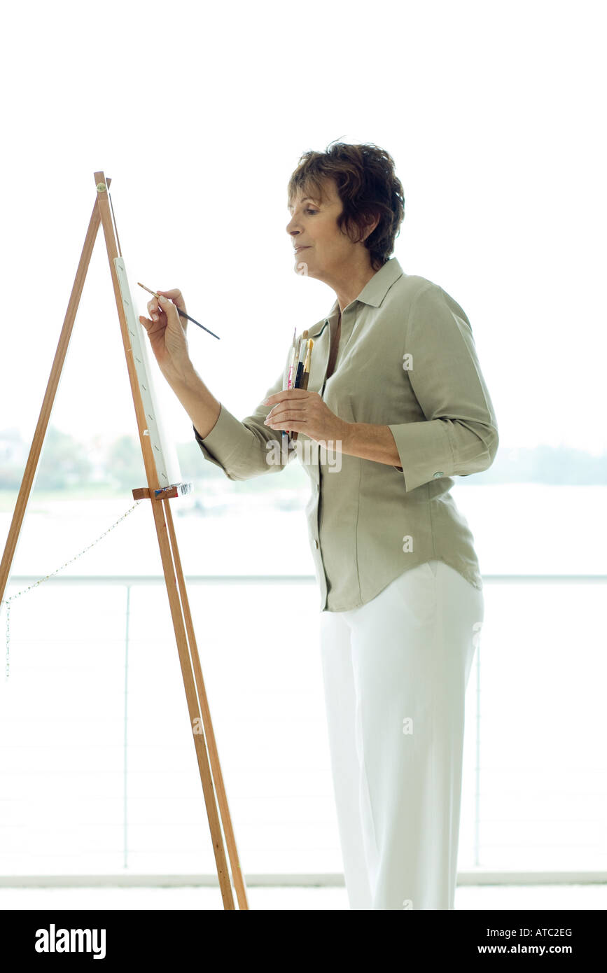Senior woman painting canvas, side view Stock Photo - Alamy