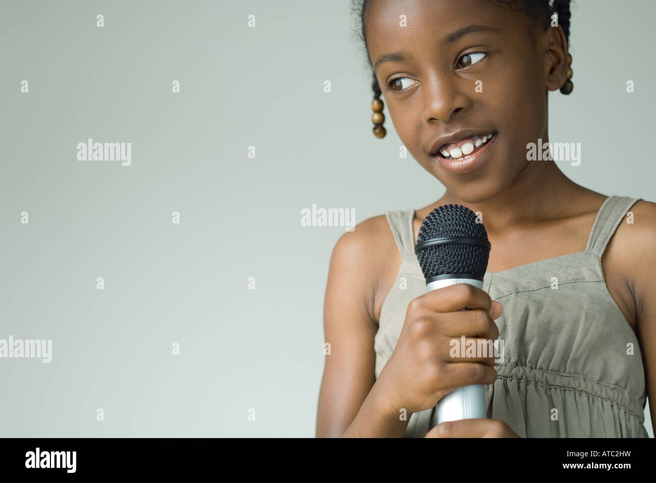Girl holding up microphone, looking away, close-up Stock Photo - Alamy