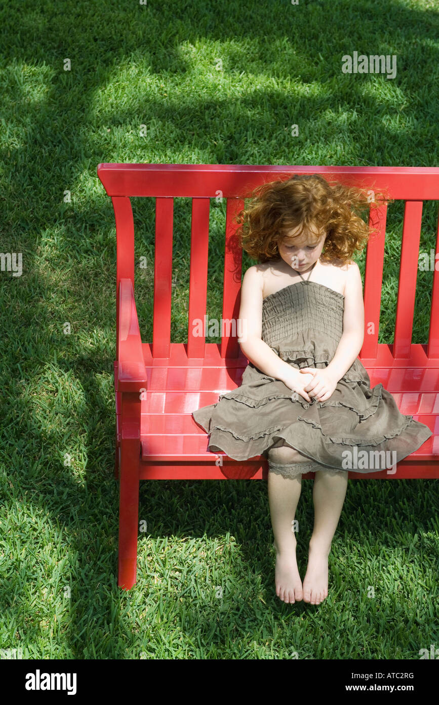 Girl sitting on red bench, high angle view Stock Photo - Alamy