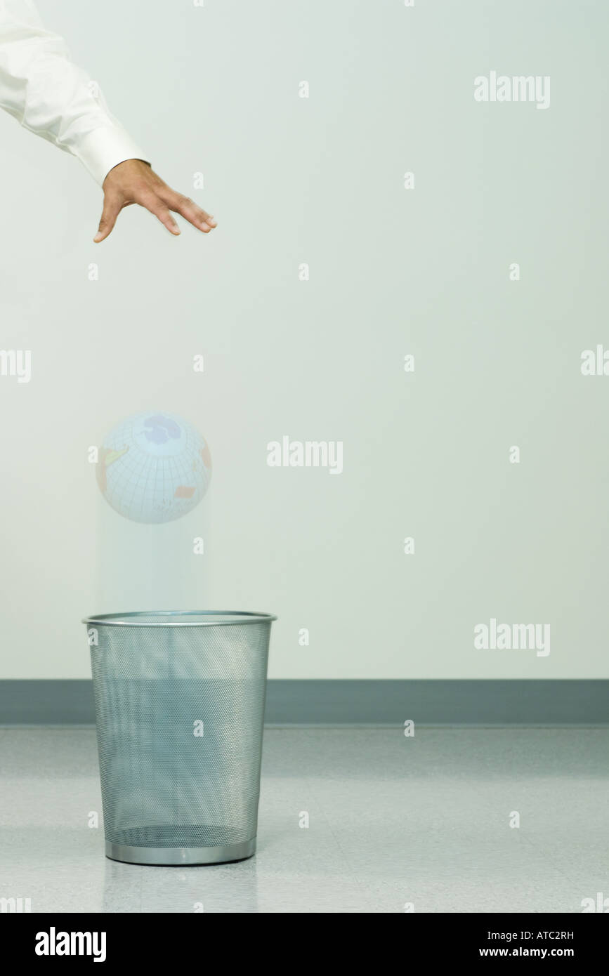 Businessman dropping globe into trash can, cropped view Stock Photo - Alamy