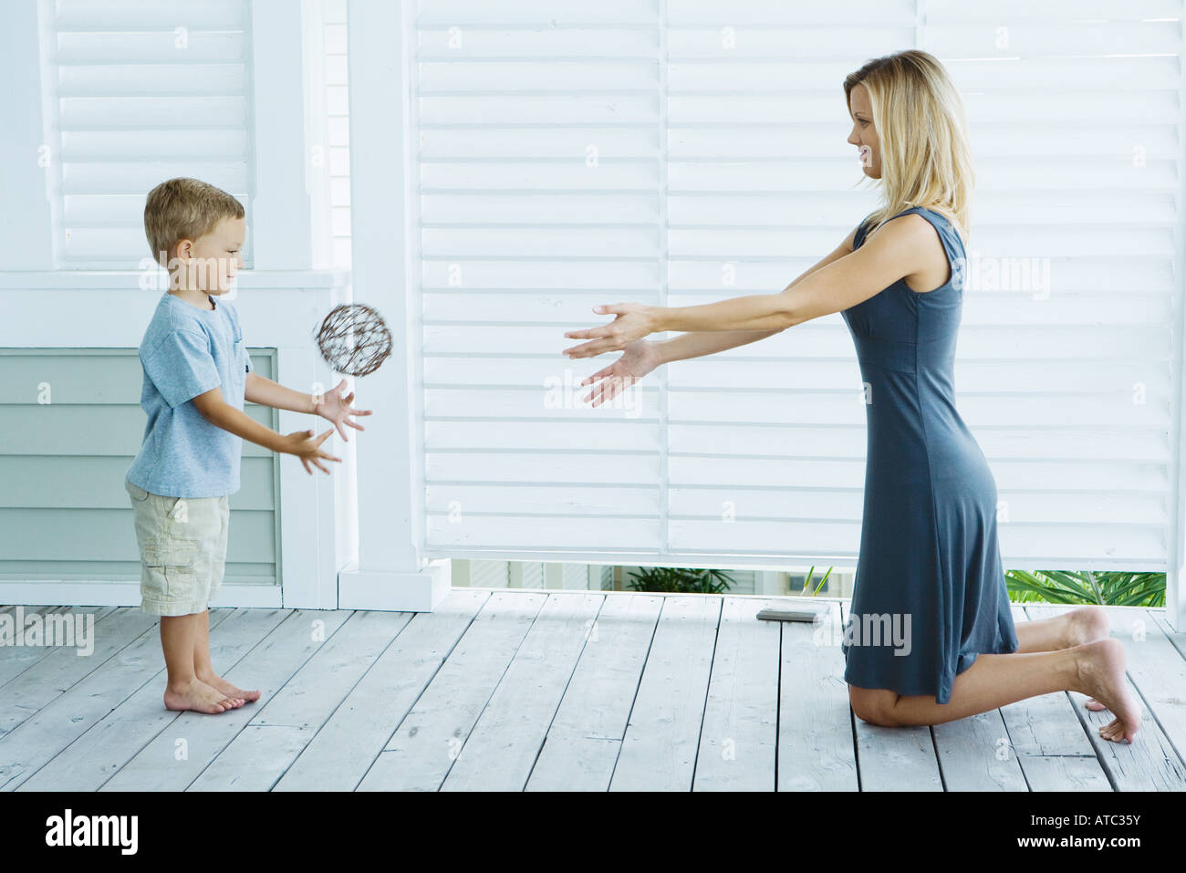 Mother and son face to face, throwing ball, side view Stock Photo - Alamy