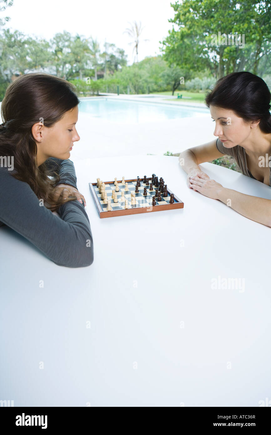 Mother and daughter playing chess together outdoors, side view Stock ...