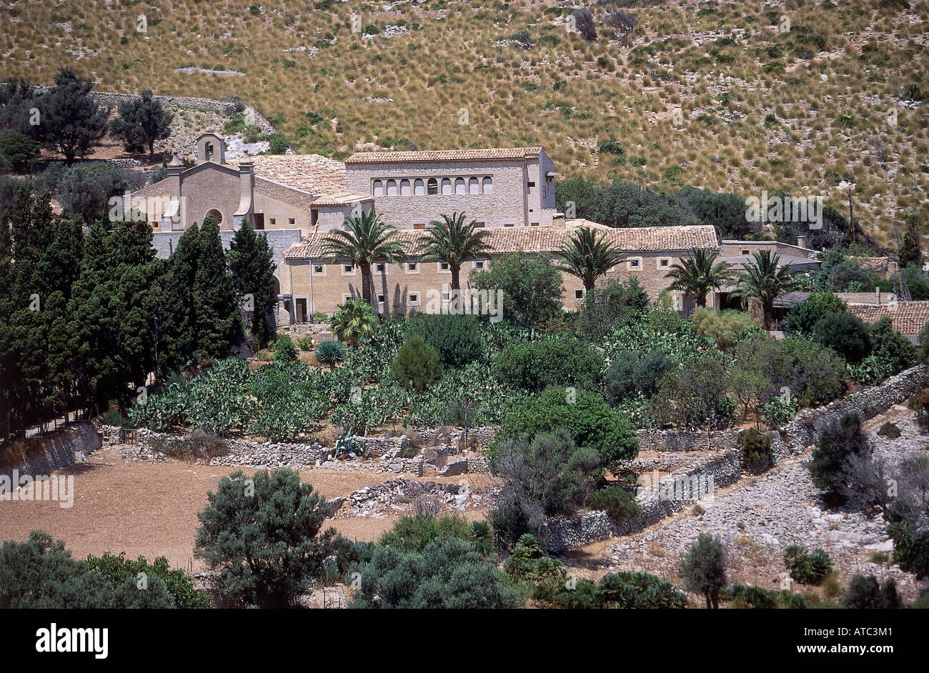 A view of the Ermita de Betlem whose stone buildings set amidst trees ...