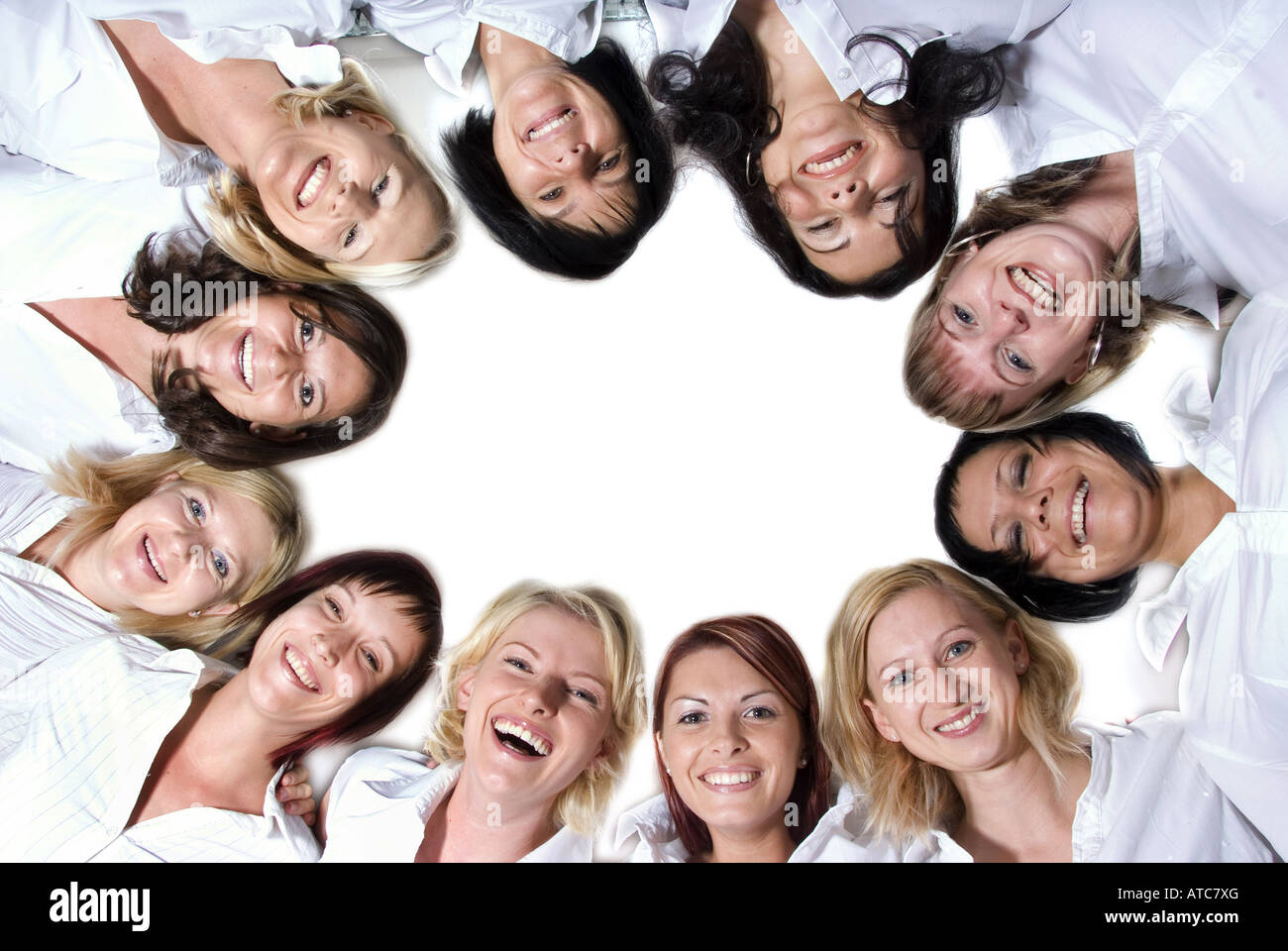 eleven, young women embracing, forming a circle and looking towards the ...