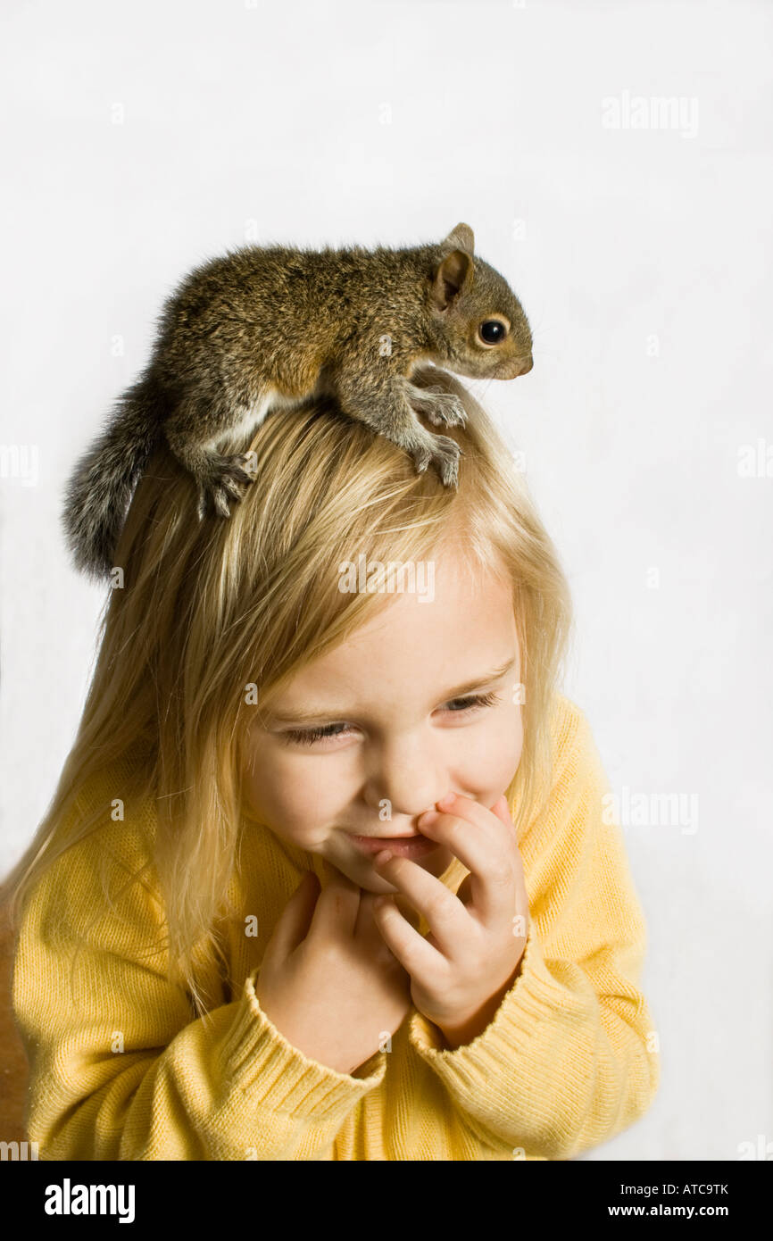 Cute girl with a pet squirrel on her head Stock Photo - Alamy