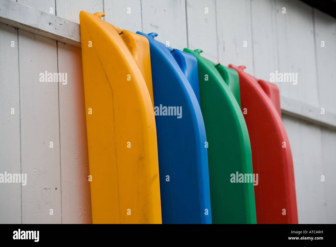 multicolored plastic elements hanging on a white wall Stock Photo - Alamy