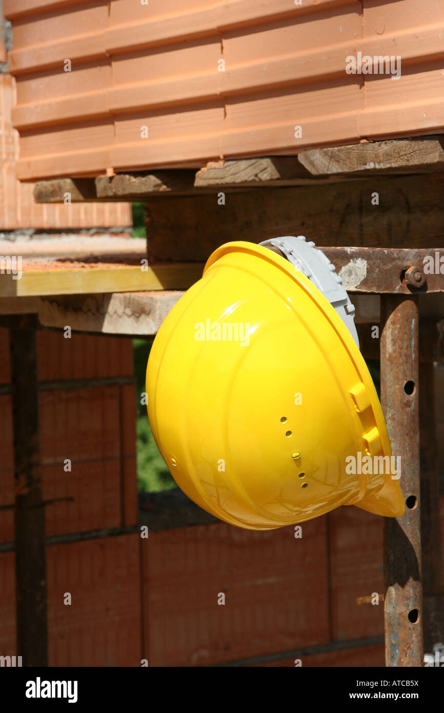 yellow work helmet on a building site Stock Photo - Alamy