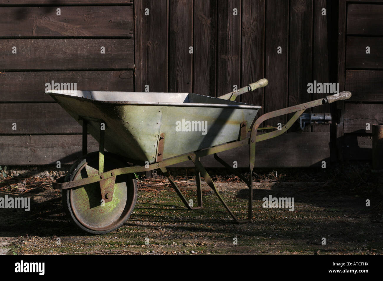 Old wheel barrow outside stable Stock Photo - Alamy