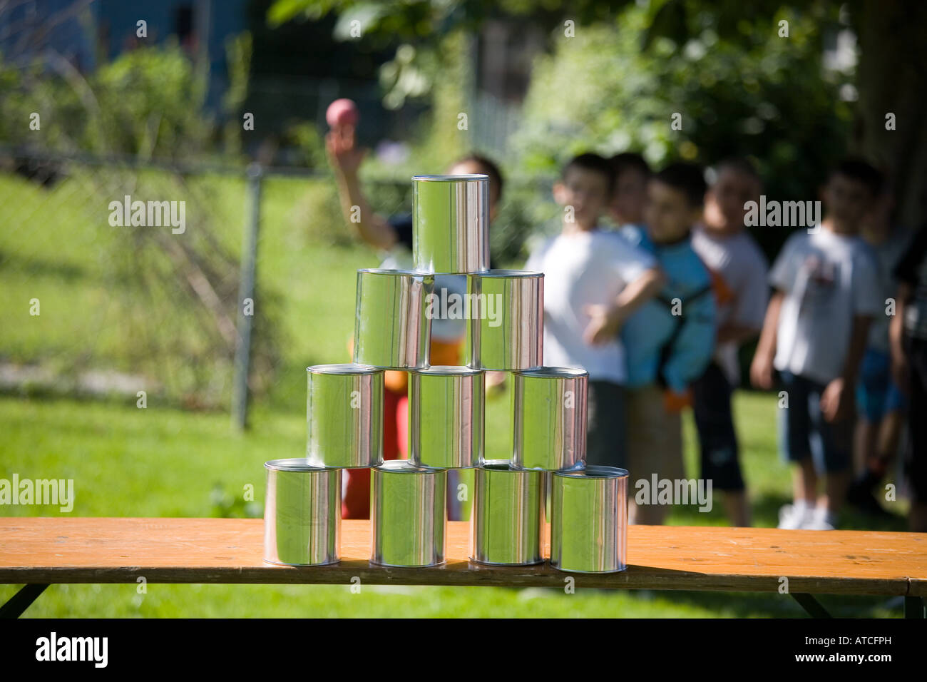 Children throw with small ball on pyramid of cans Stock Photo - Alamy