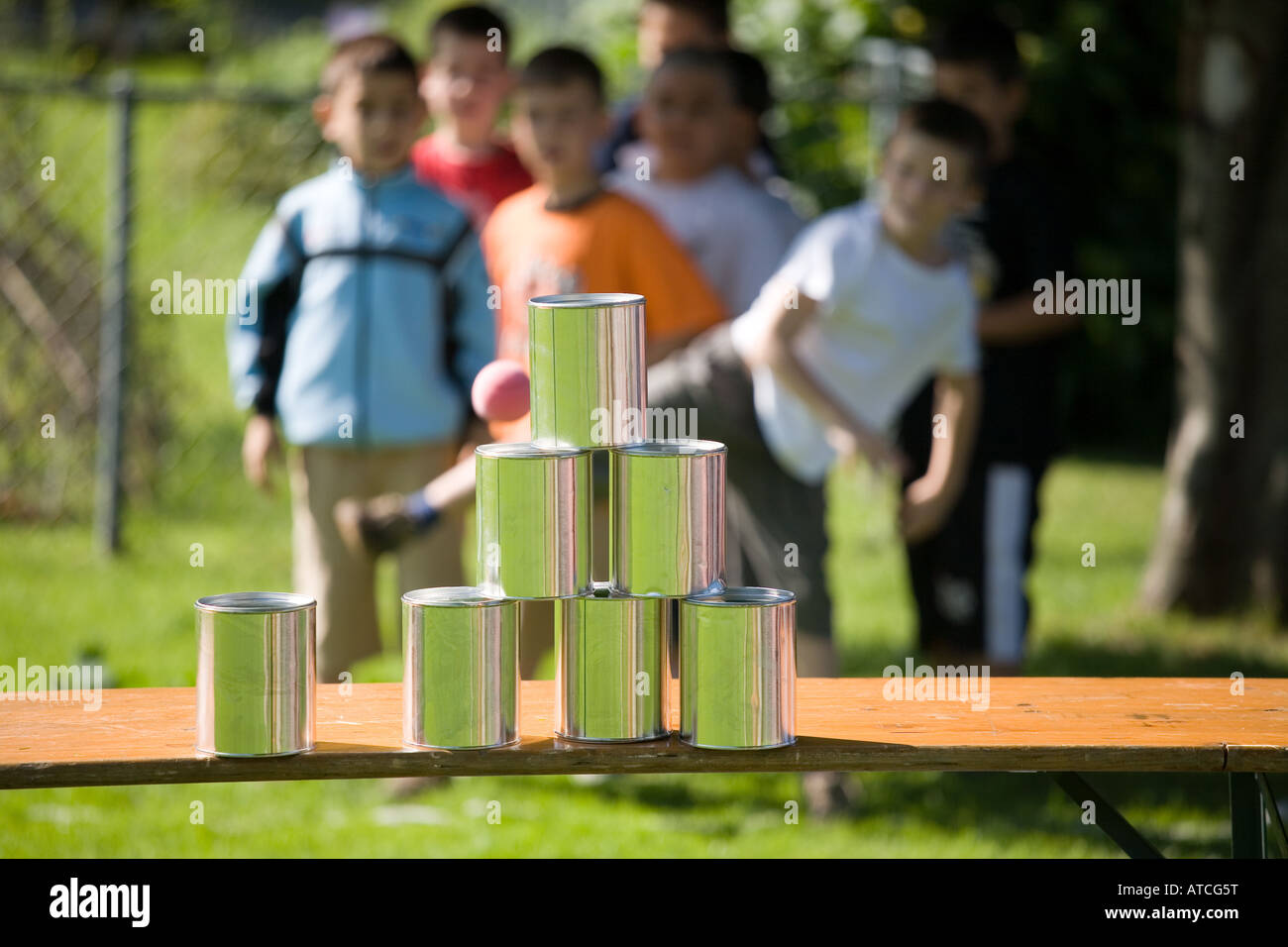 Children throw with small ball on pyramid of cans Stock Photo - Alamy