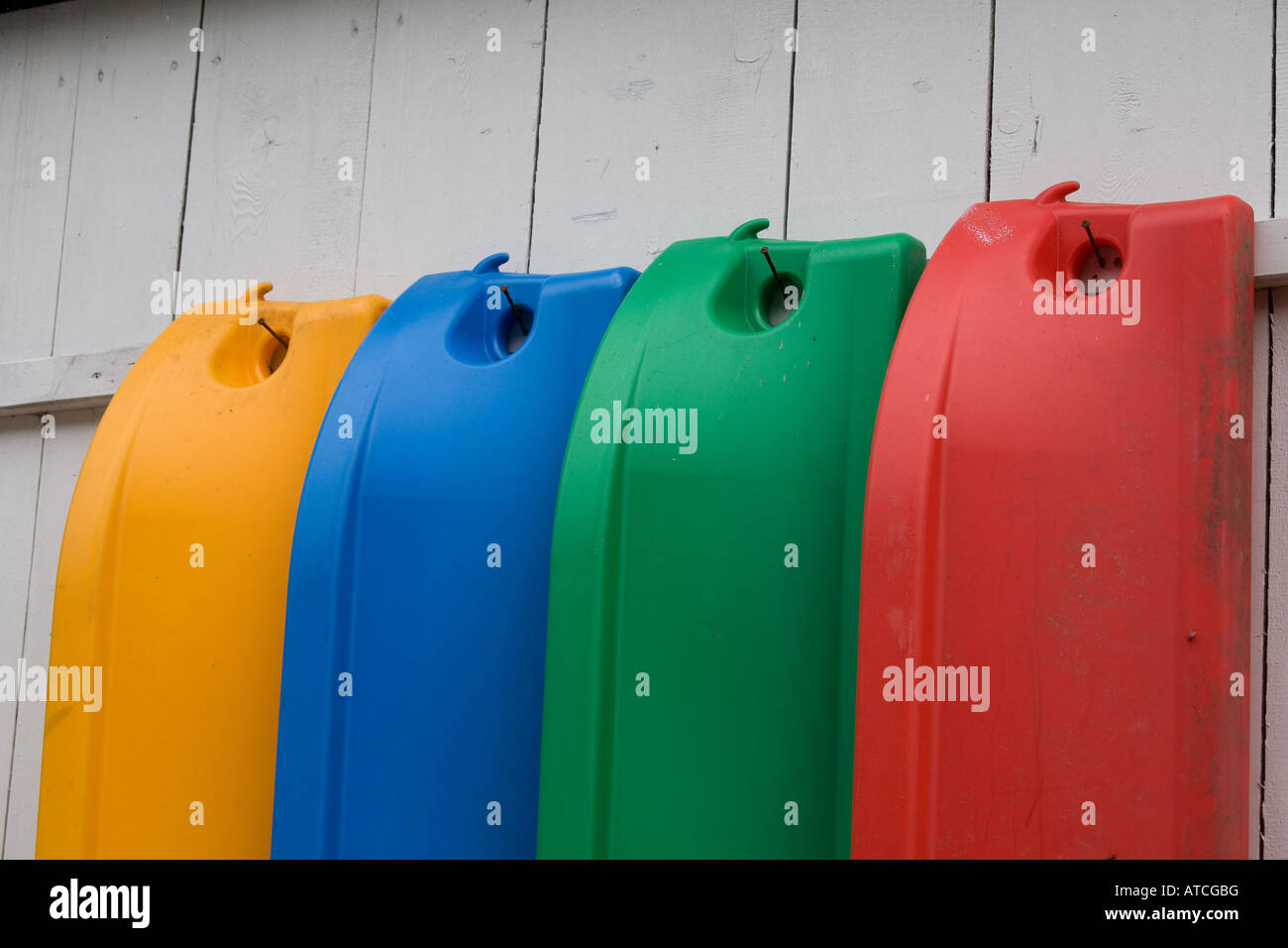 multicolored plastic elements hanging on a white wall Stock Photo - Alamy