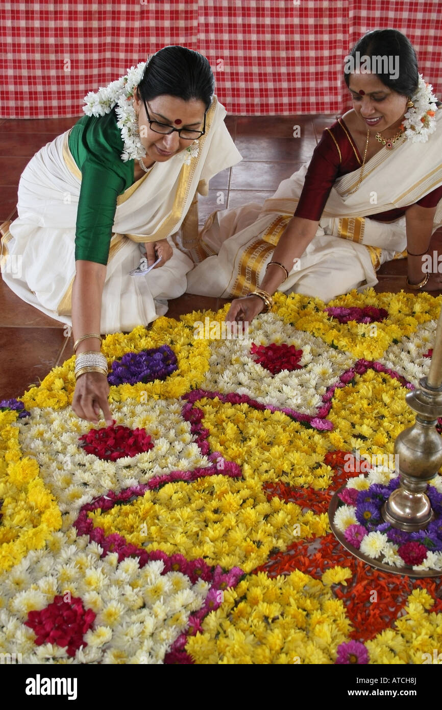 Hindu Ladies make finishing touches to a pookalam or flower carpet for ...