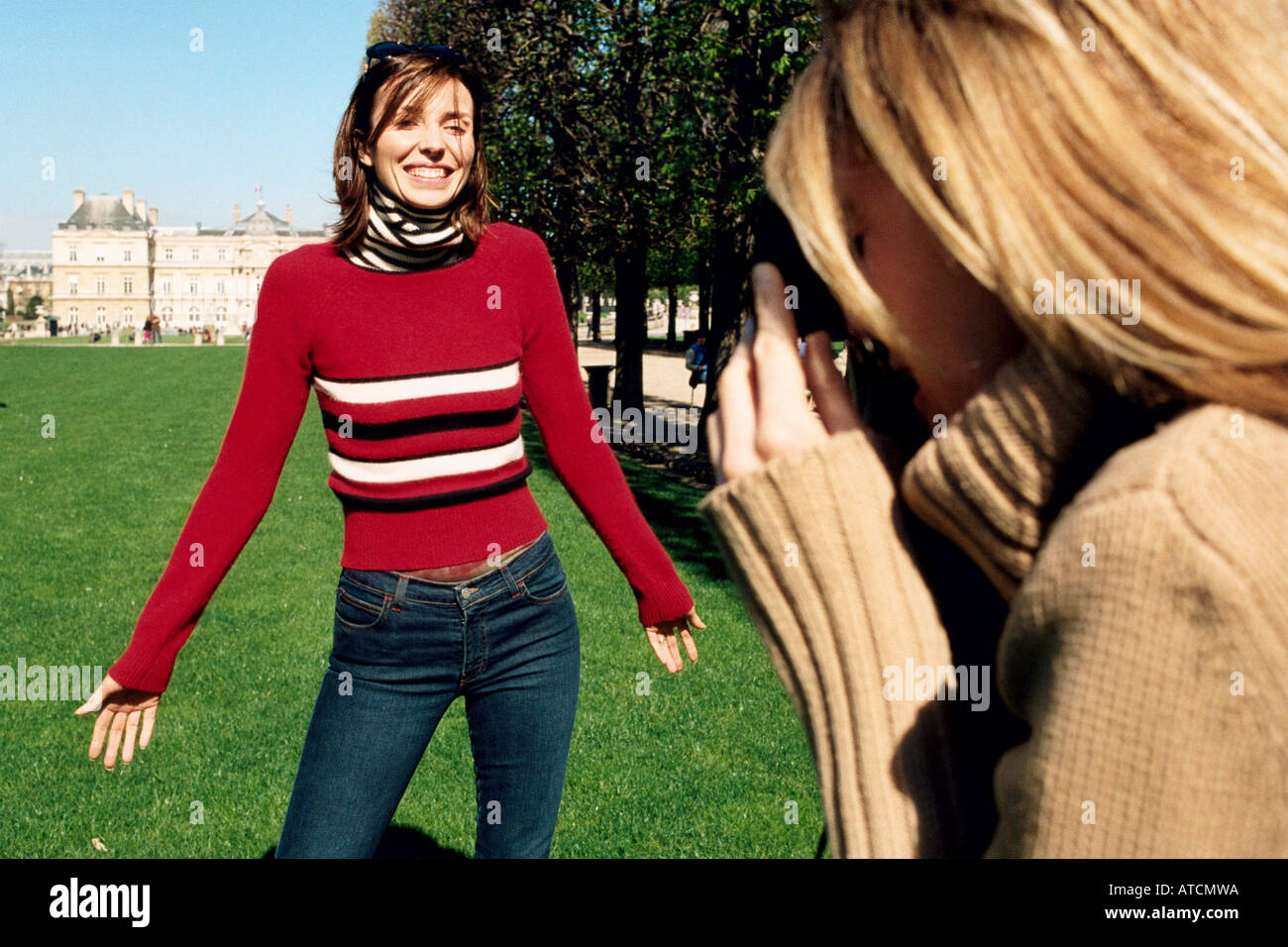 Woman taking photographs of another woman in park, Paris, France Stock ...