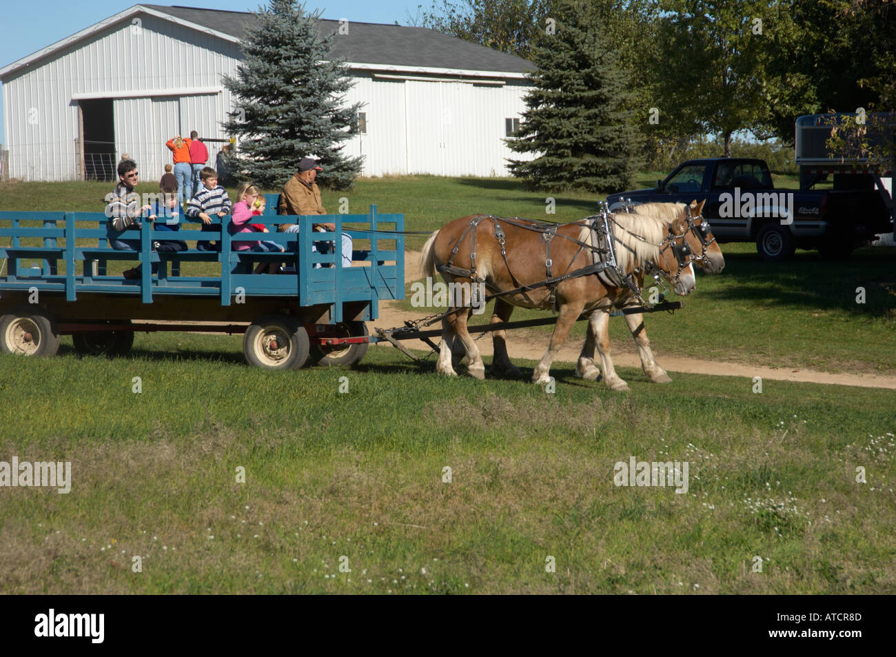 Horses pulling family on hay ride Stock Photo - Alamy