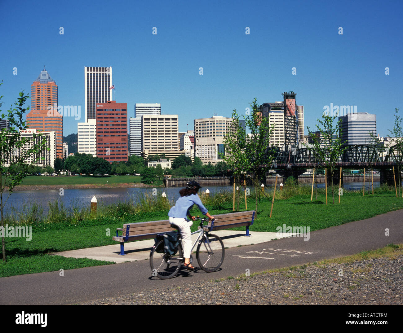 A bicyclist pedaling along the riverfront bike path in Portland, Oregon ...