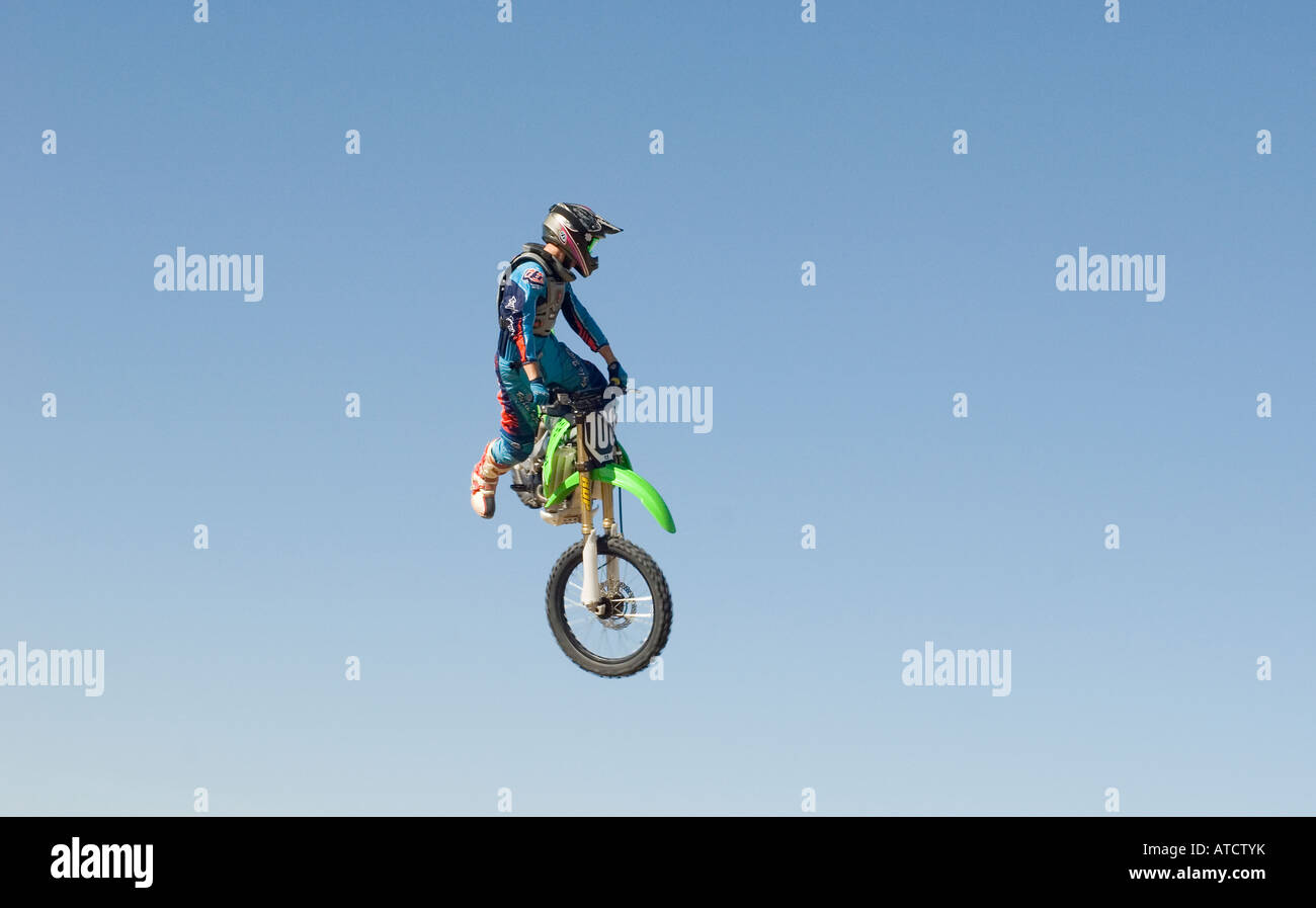 Dirt bike motorcycle rider jumping doing a trick at motocross track ...