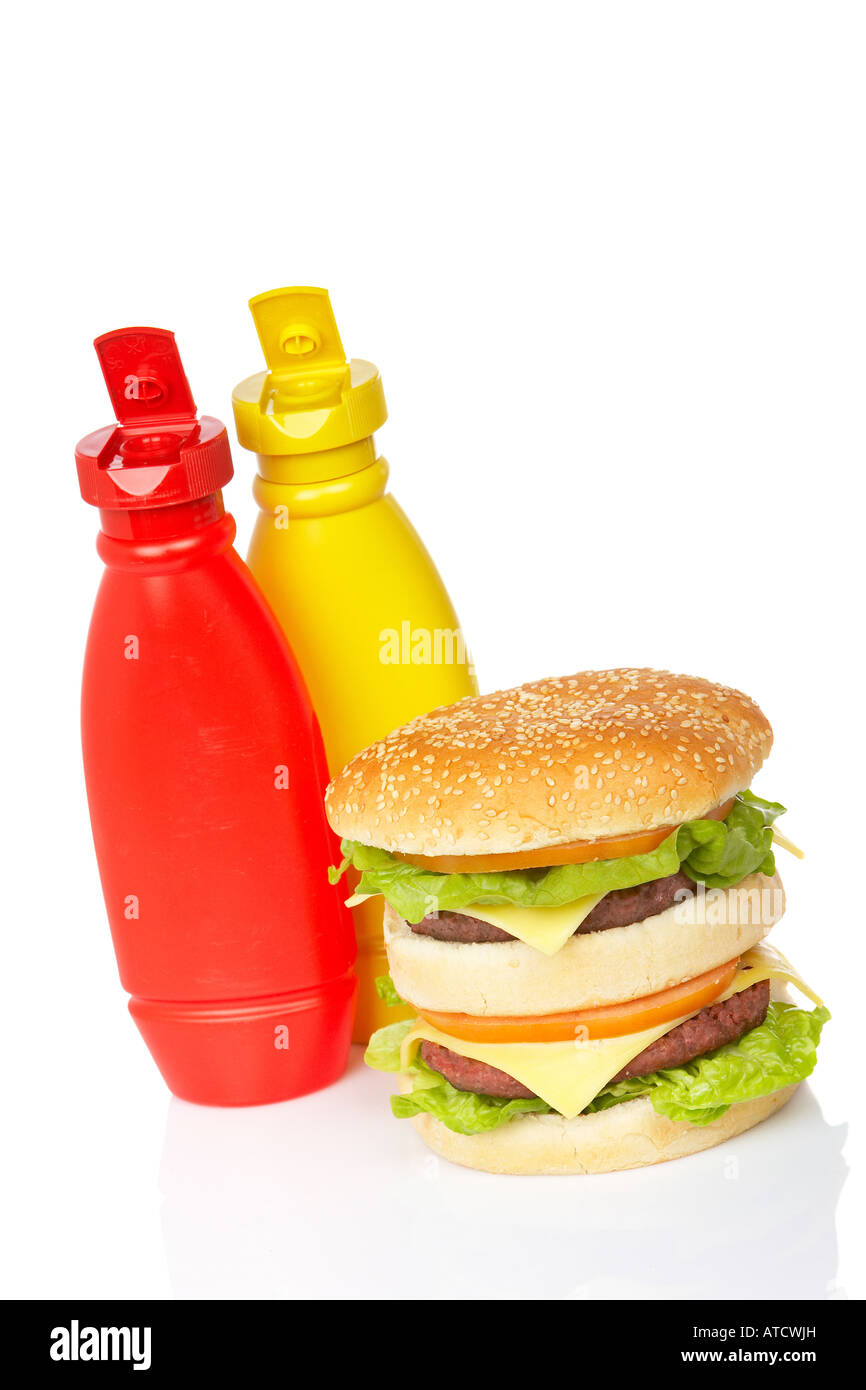 Double cheeseburger with mustard and ketchup bottles reflected on white ...