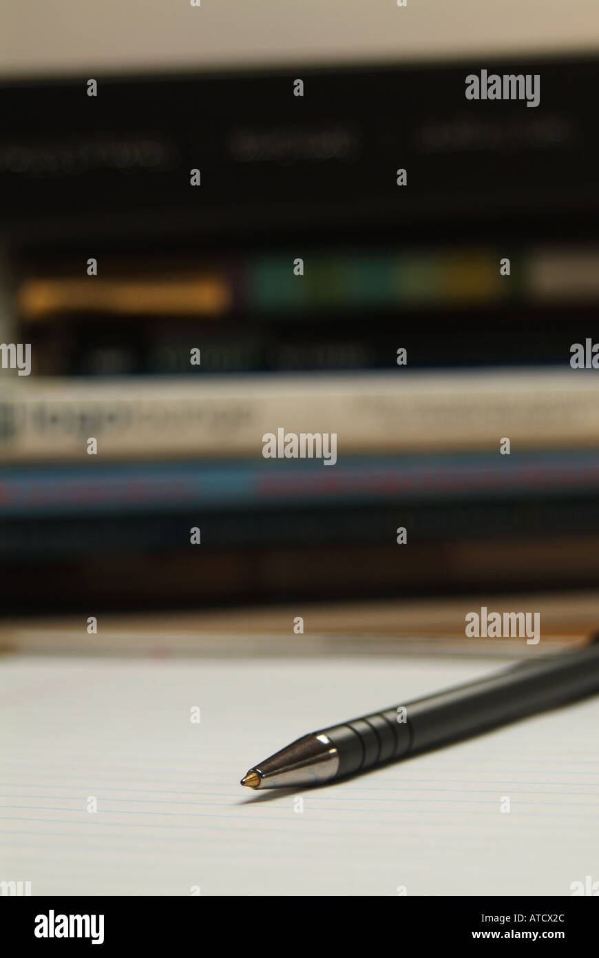 pen and paper with books in background Stock Photo - Alamy