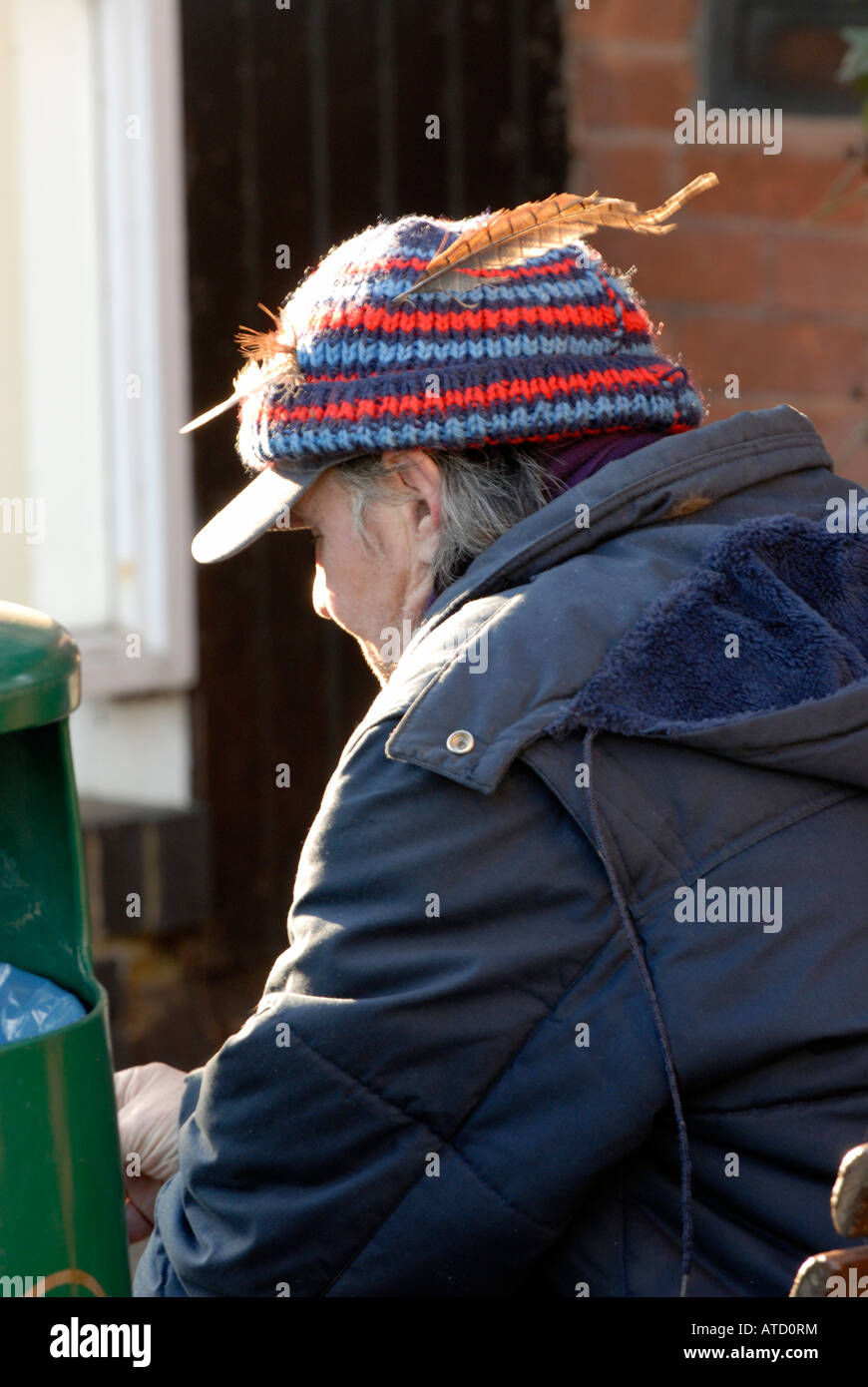a homeless person man wearing a tea cosy bobble hat made of wool woolen ...