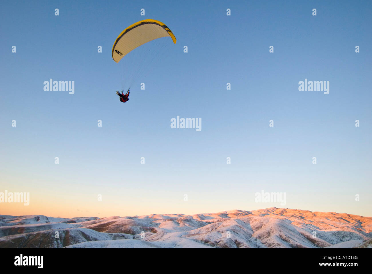A paraglider flying high at sunset Stock Photo - Alamy
