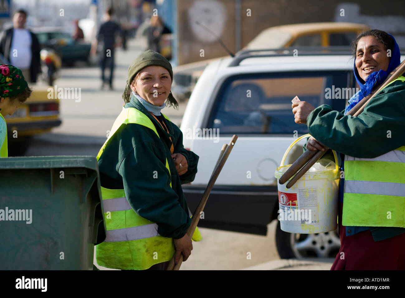 refuse-collectors happy on the street among cars takeing away the ...