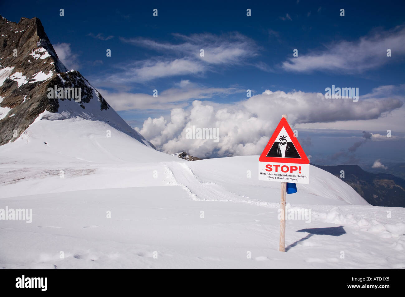 Danger sign behind rope barrier warns of glacier crevasse Alps mountain ...