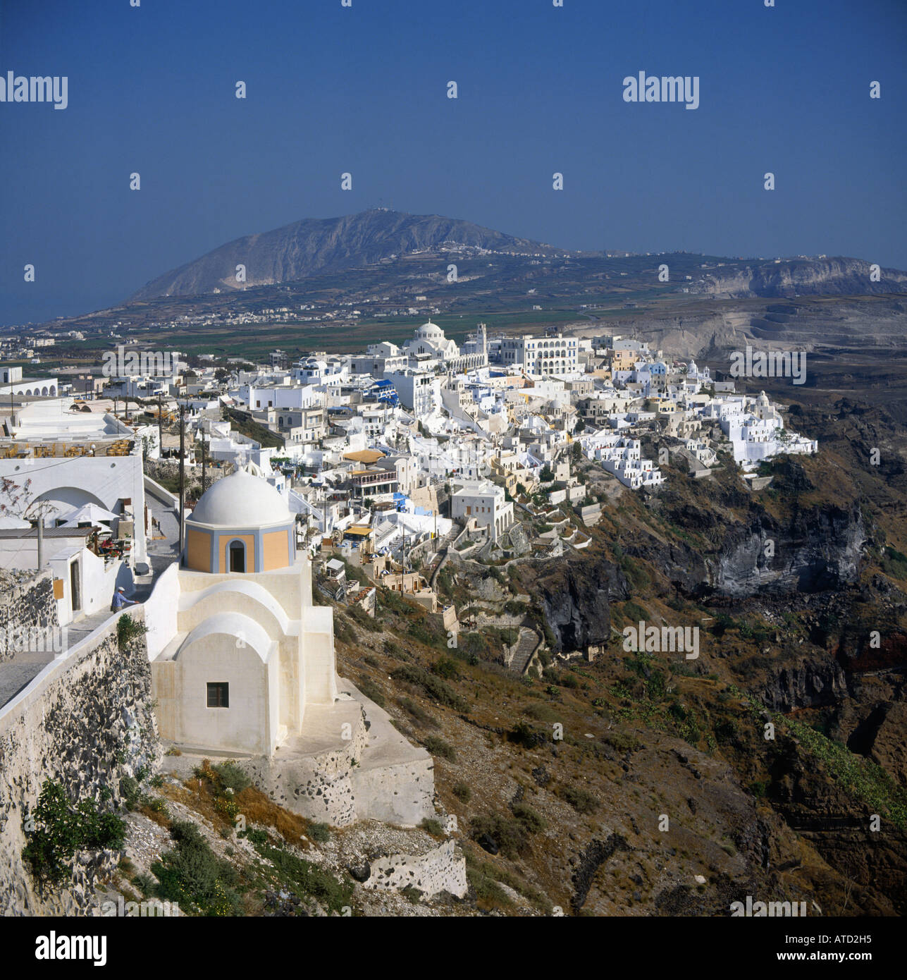 Cliff top view of white clustered buildings of the town Fira in ...