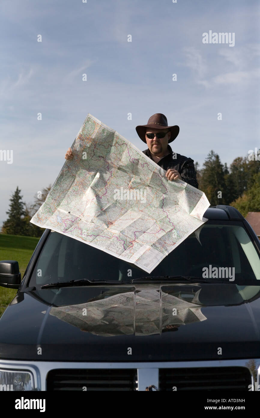 Driver looks for the way with map Stock Photo - Alamy