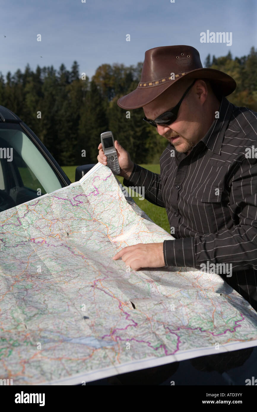 Driver looks for the way with map Stock Photo - Alamy