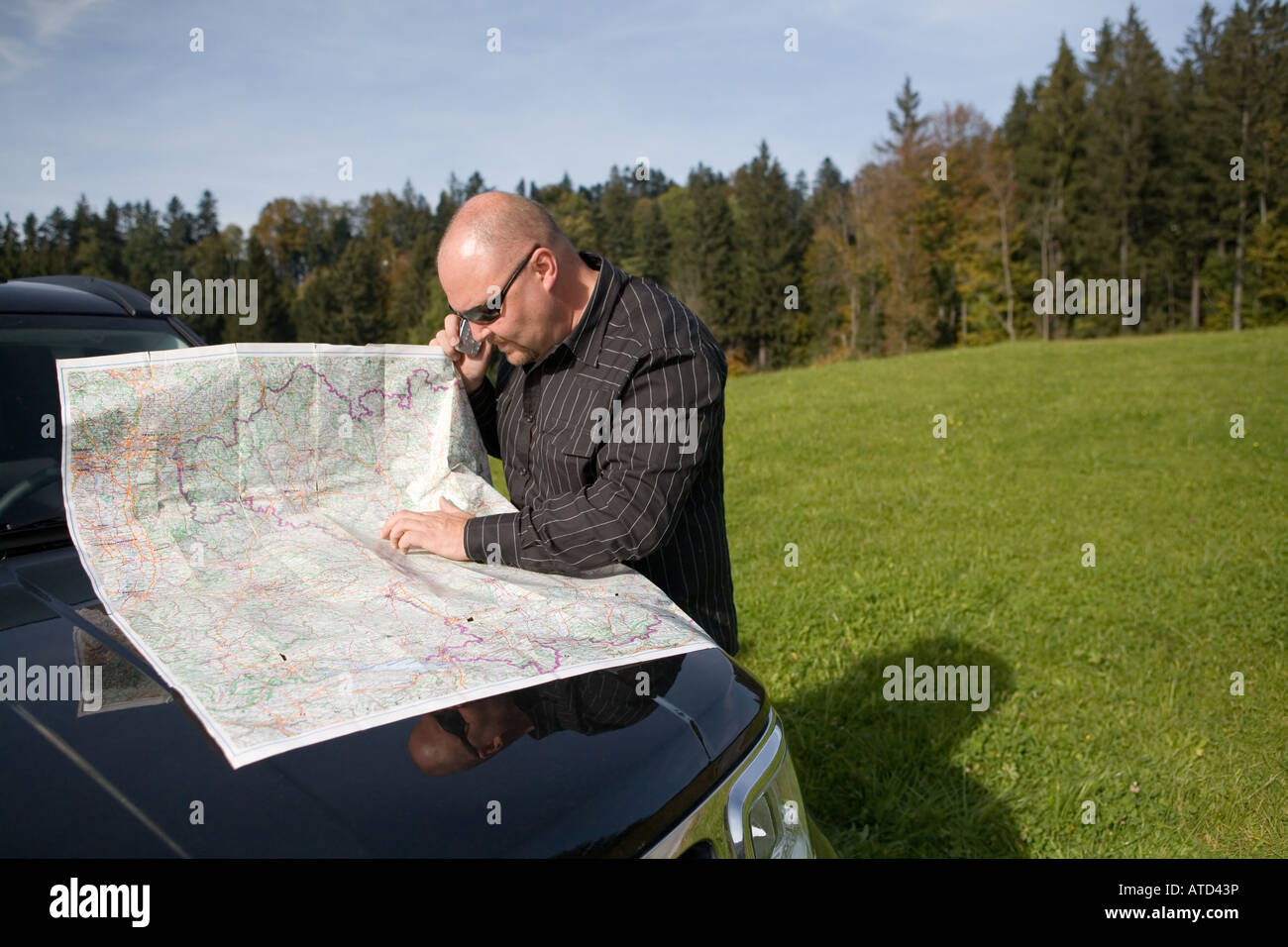 Driver looks for the way with map Stock Photo - Alamy