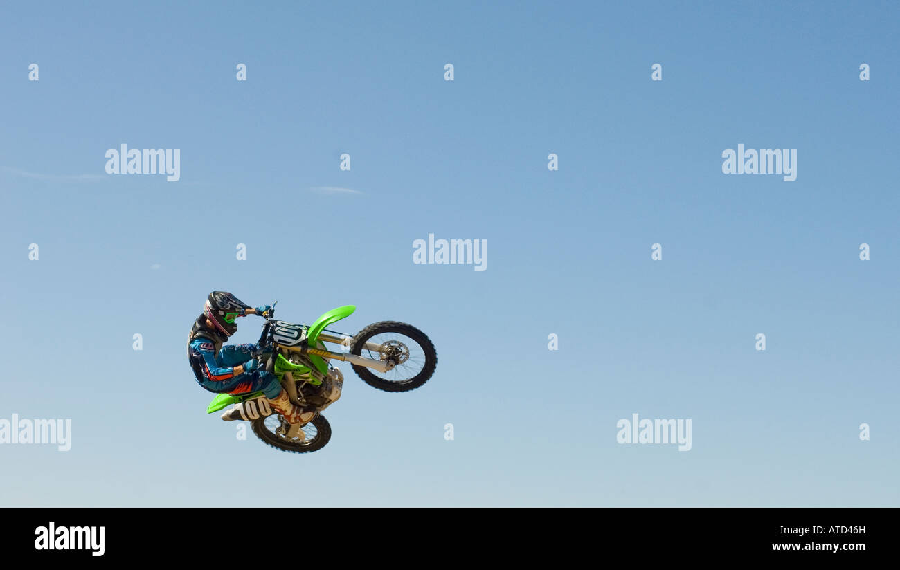 Dirt bike motorcycle rider jumping doing a trick at motocross track ...