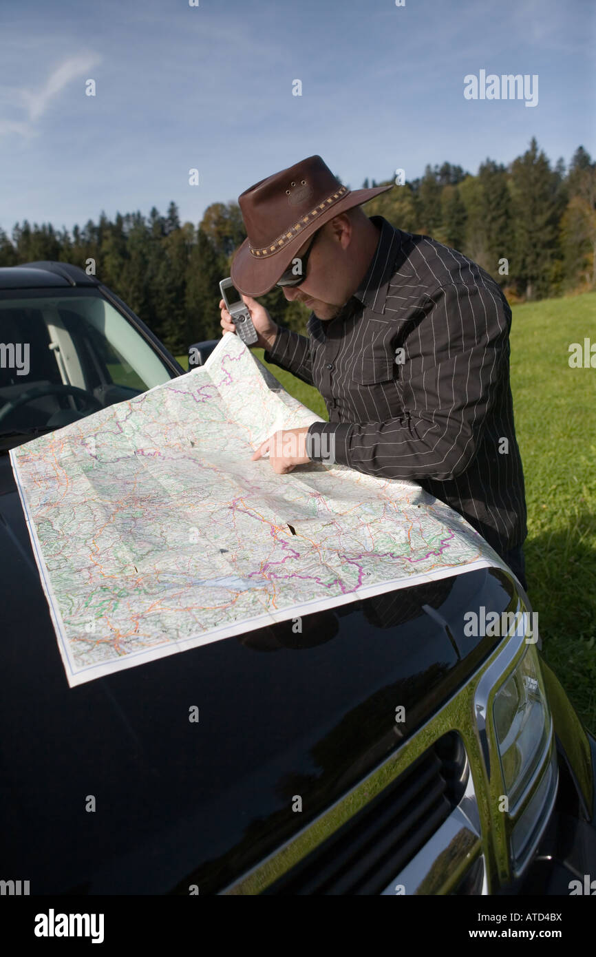 Driver looks for the way with map Stock Photo - Alamy