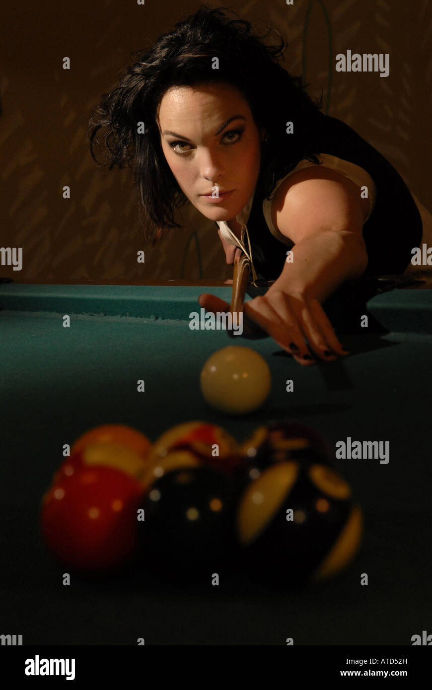 Dark haired woman playing pool billiards Stock Photo - Alamy